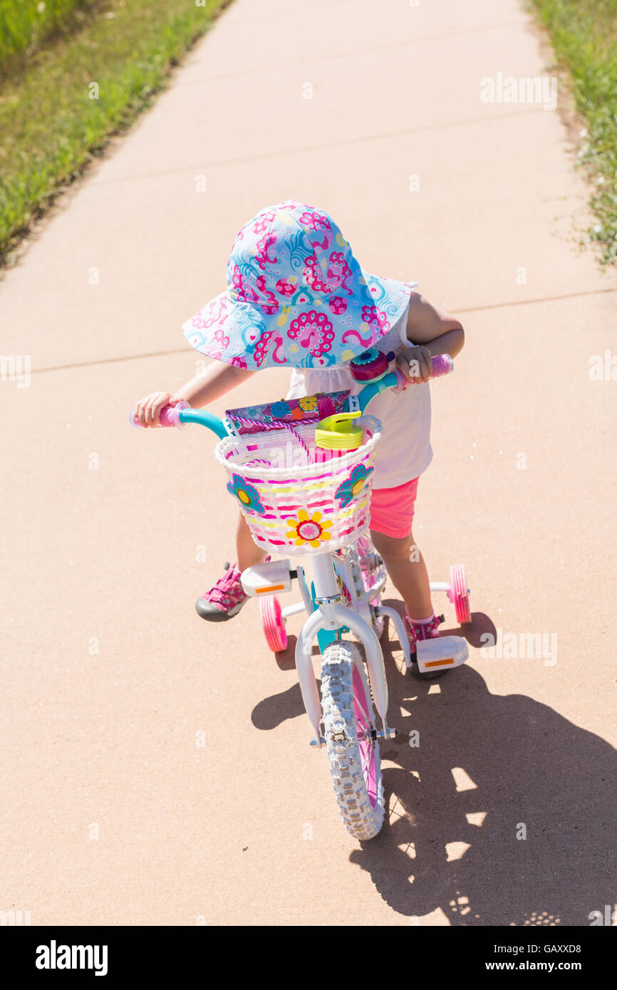 Toddler learning how to ride her first bike Stock Photo - Alamy