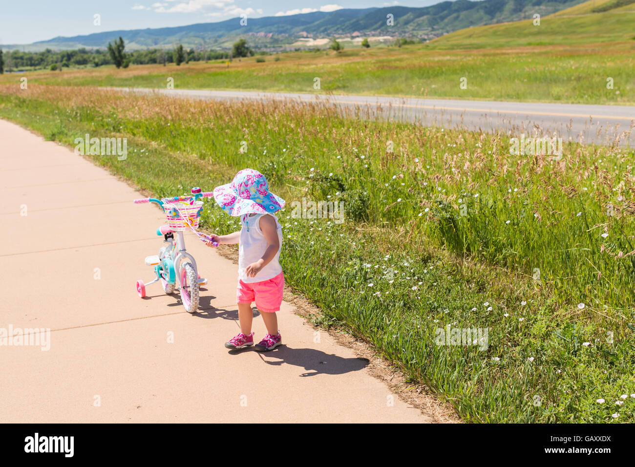 Toddler learning how to ride her first bike Stock Photo - Alamy