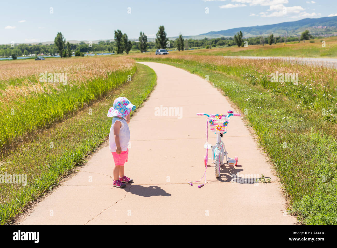 Toddler learning how to ride her first bike Stock Photo - Alamy