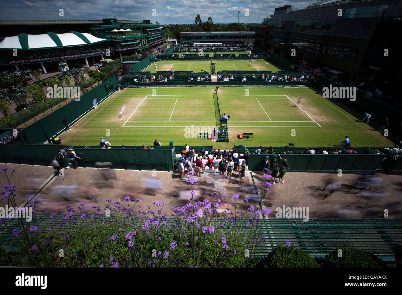 General view of the action on the outside courts and spectators walking ...