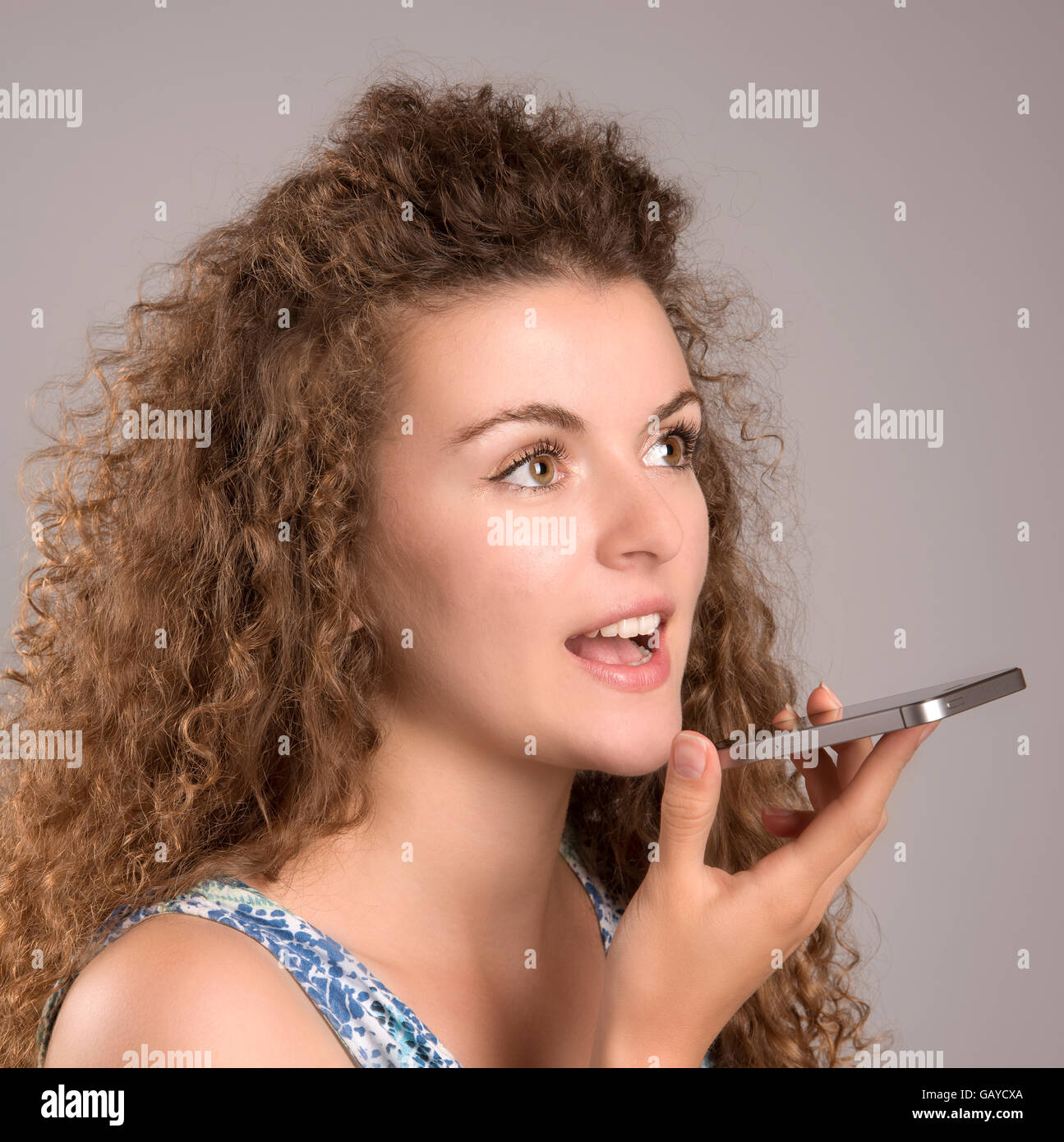 A teenage girl speaking into a mobile phone Stock Photo - Alamy