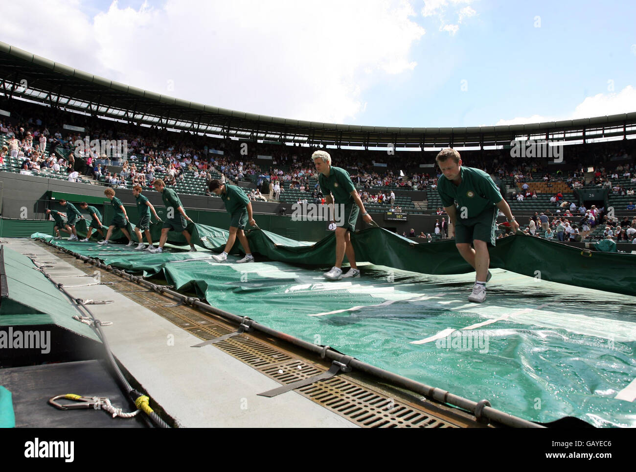 The covers are removed following the first rain break on Court One ...
