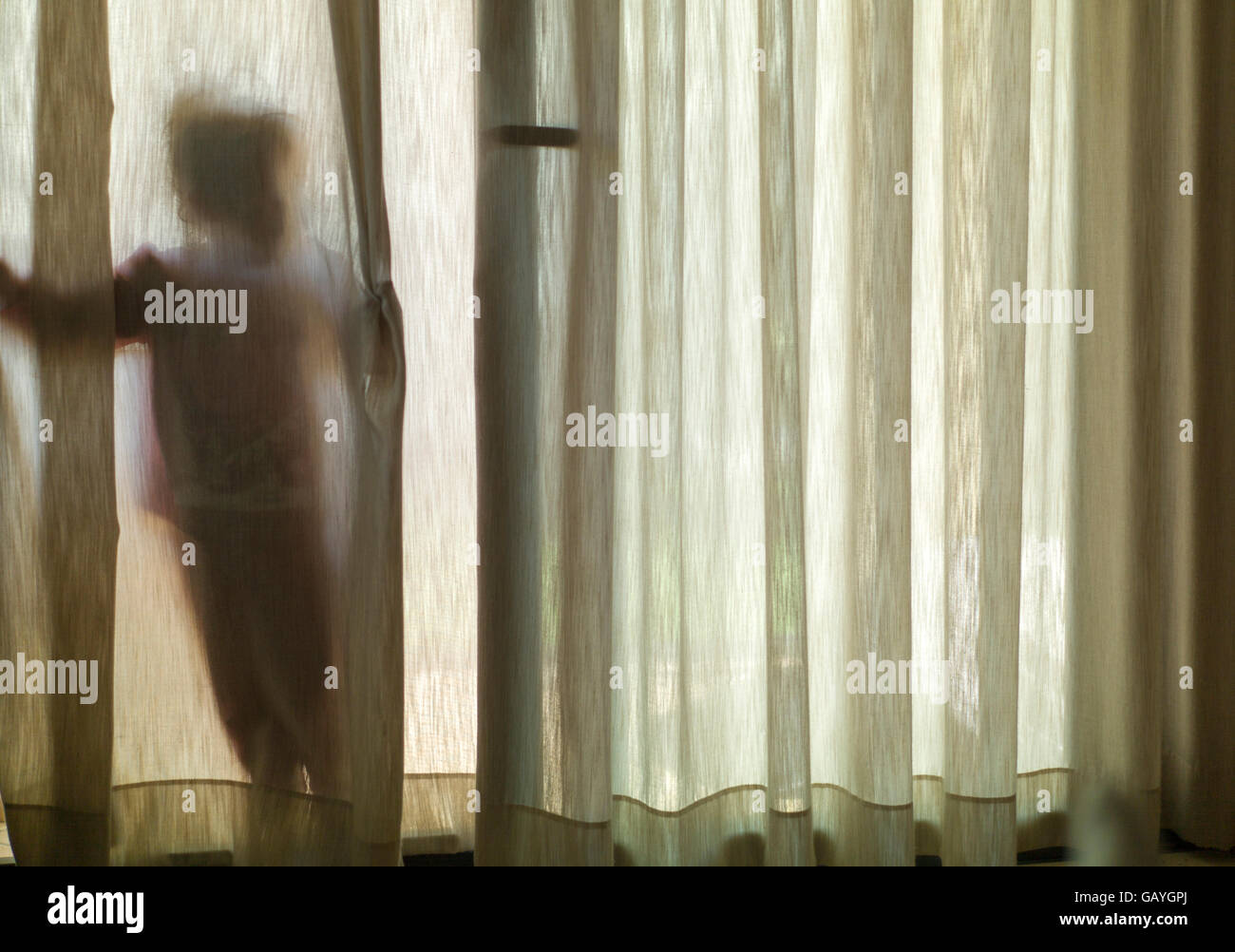 Child hiding behind the curtain Stock Photo - Alamy
