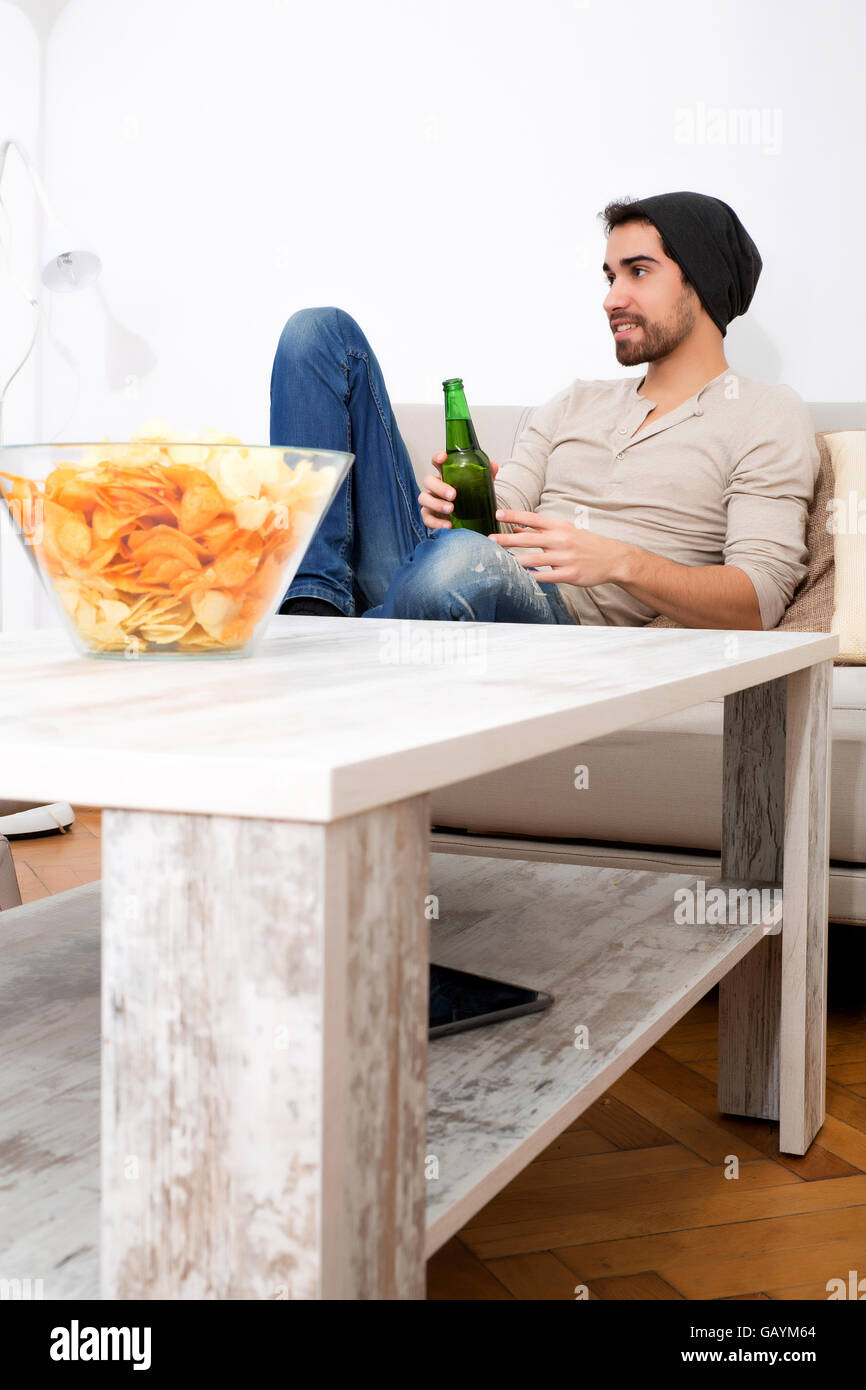 Portrait of a young man drinking beer at home Stock Photo - Alamy