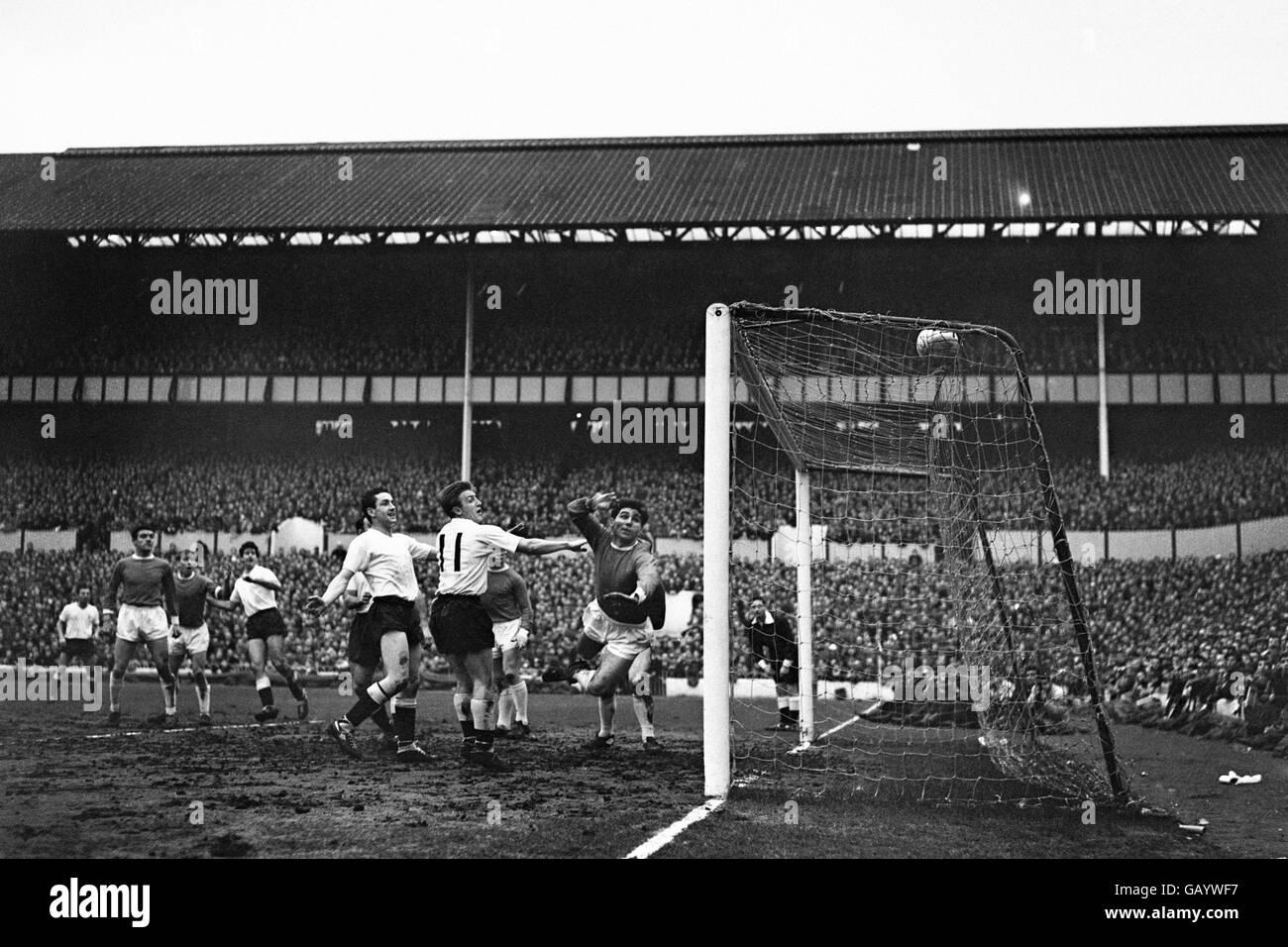 David Gaskell, United goalkeeper punches a header from Maurice Norman ...