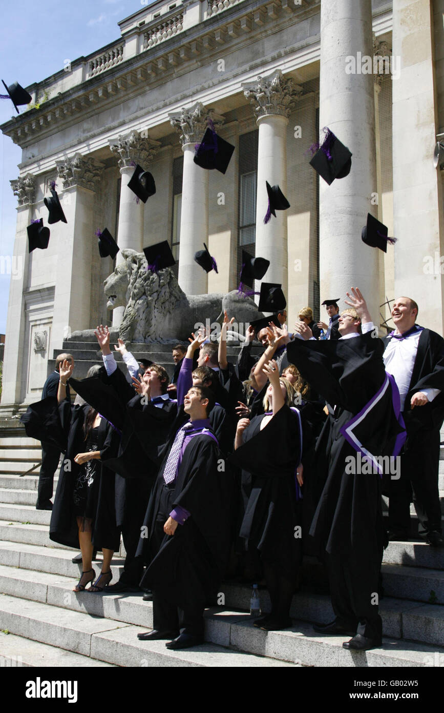 New graduates throw their mortarboard hats into the air following their ...