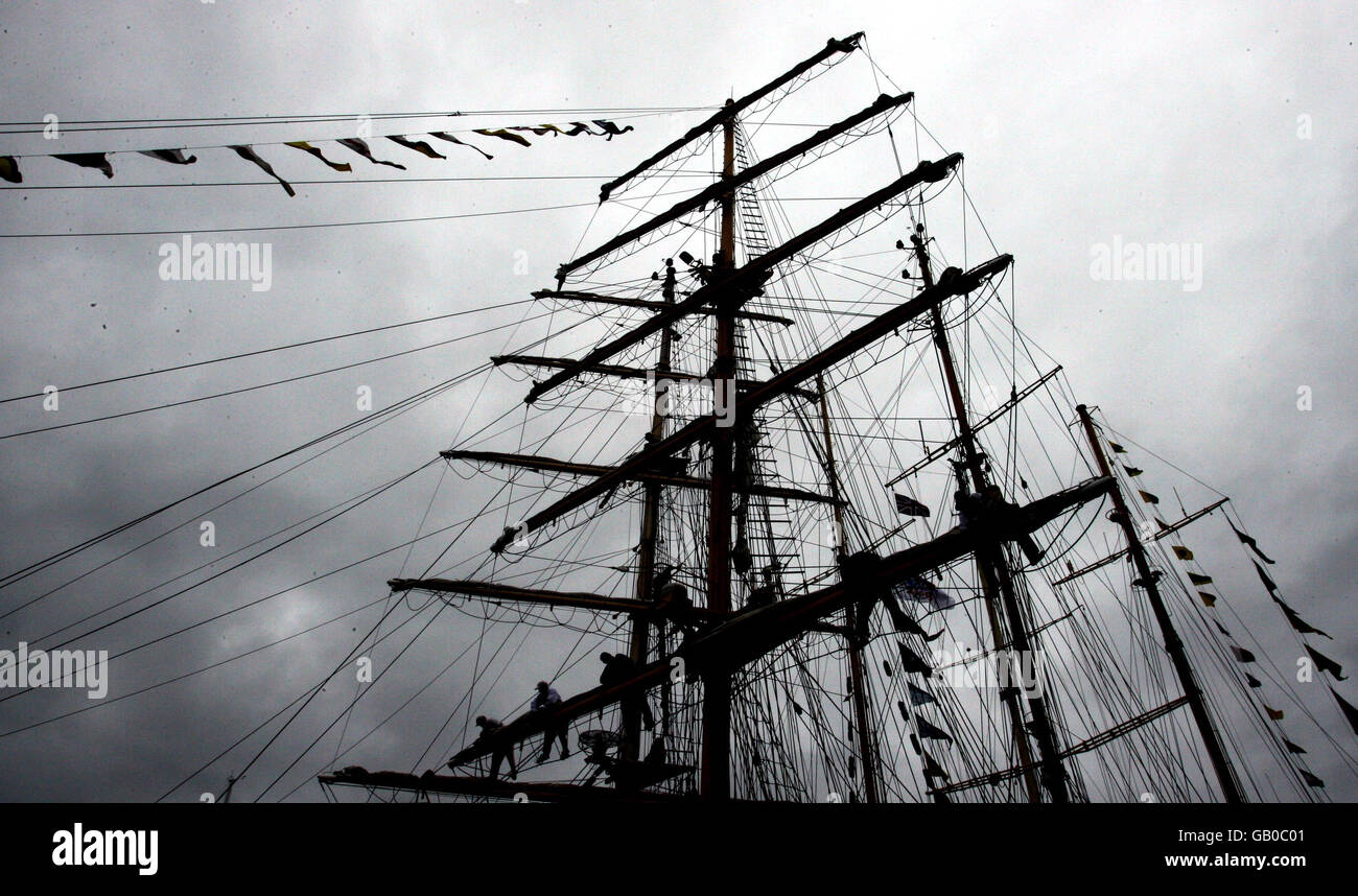 Sailors wrap up the sails on a ship moored in the Albert Dock which are ...