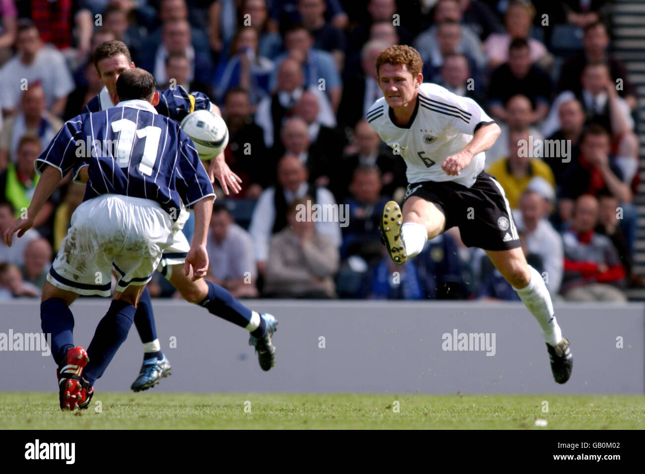 Germany's Paul Freier (r) gets in a shot despite the attention of ...