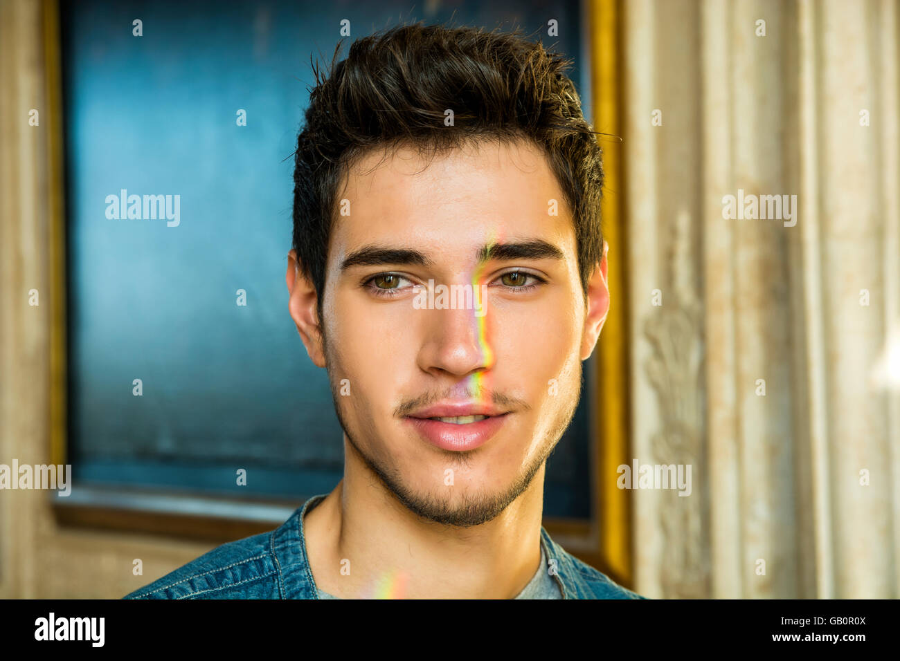 Young man showing rainbow reflection on his face Stock Photo - Alamy
