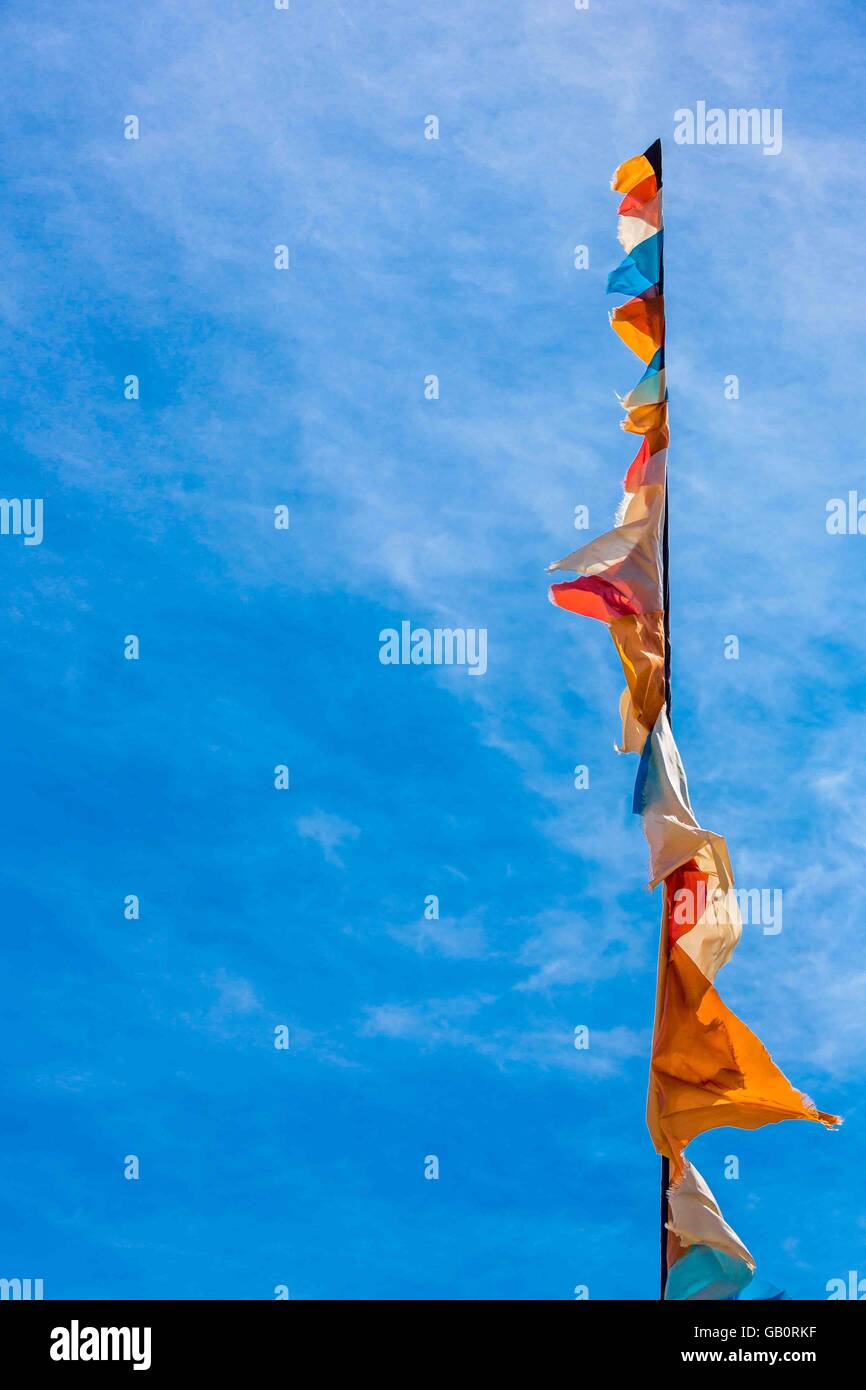 a flagpole with flags and pennants rising up into a blue sky Stock ...