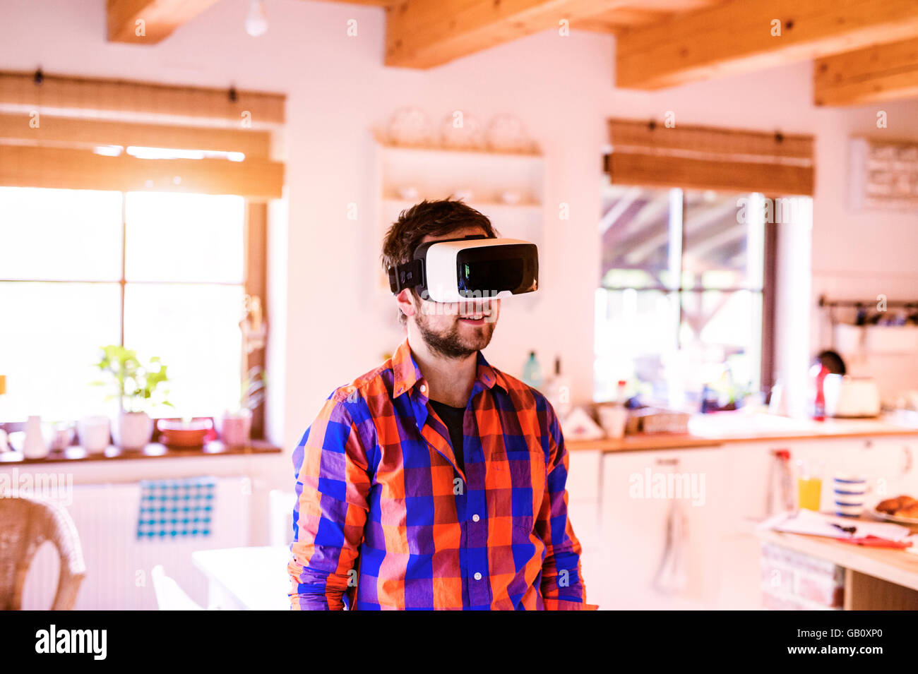 Man wearing virtual reality goggles standing in a kitchen Stock Photo ...
