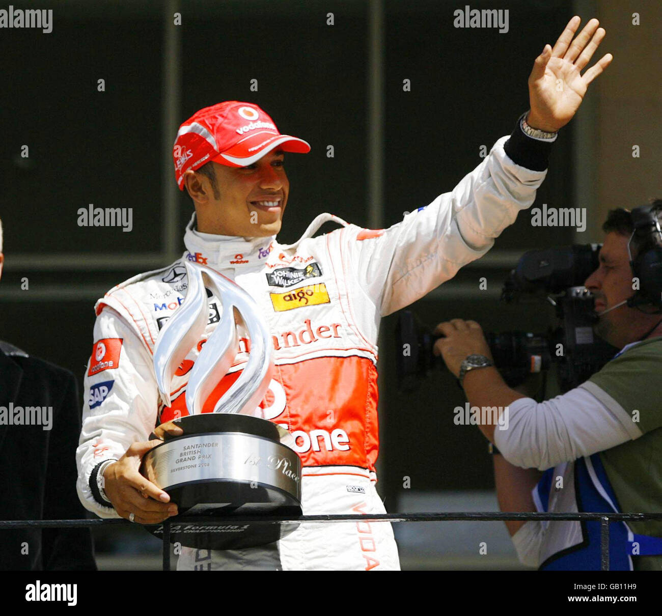 Formula One star Lewis Hamilton waves to fans holding his trophy he ...