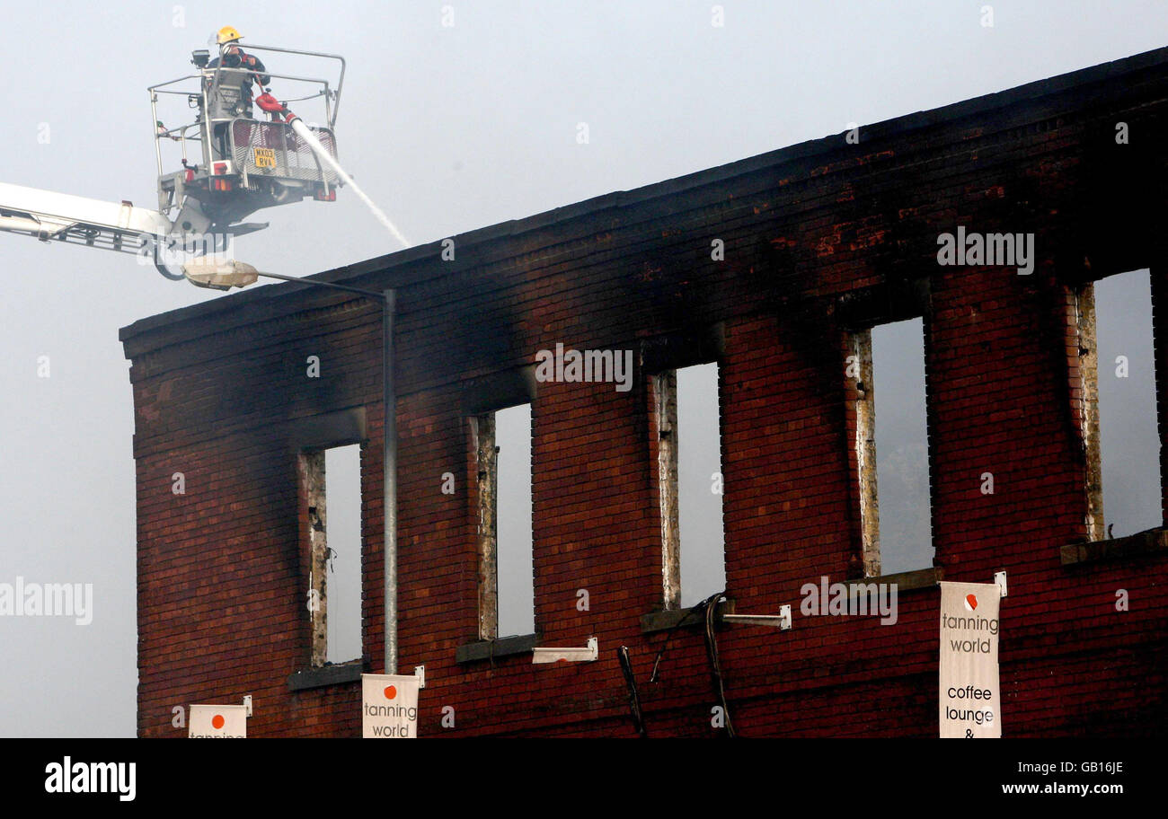 Firefighters damp down following a fire at an office block in Bolton ...