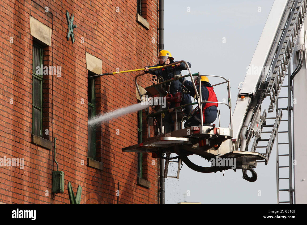 Firefighters damp down following a fire at an office block in Bolton ...