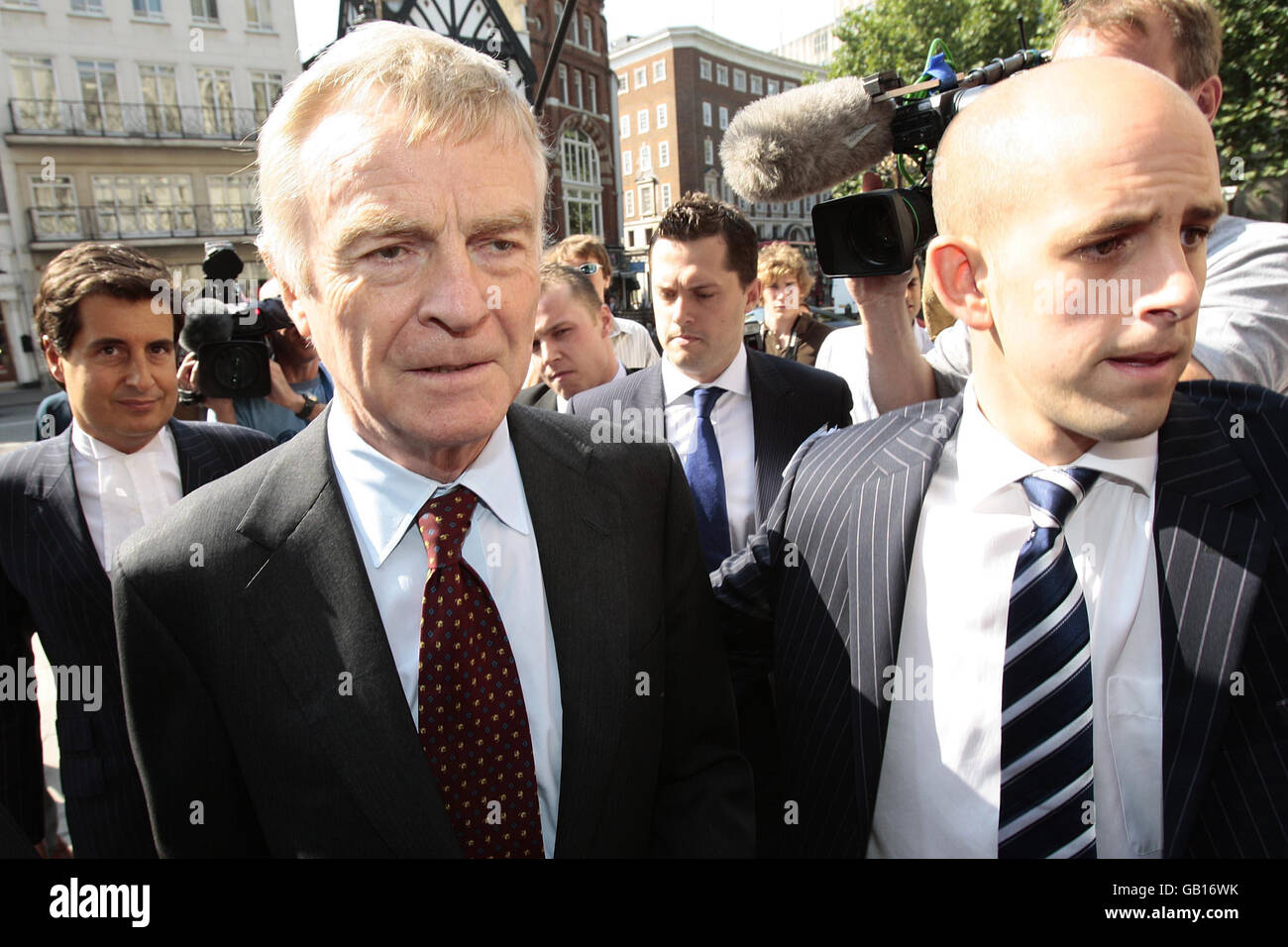 FIA President Max Mosley (left) is escorted by his security guard as he ...