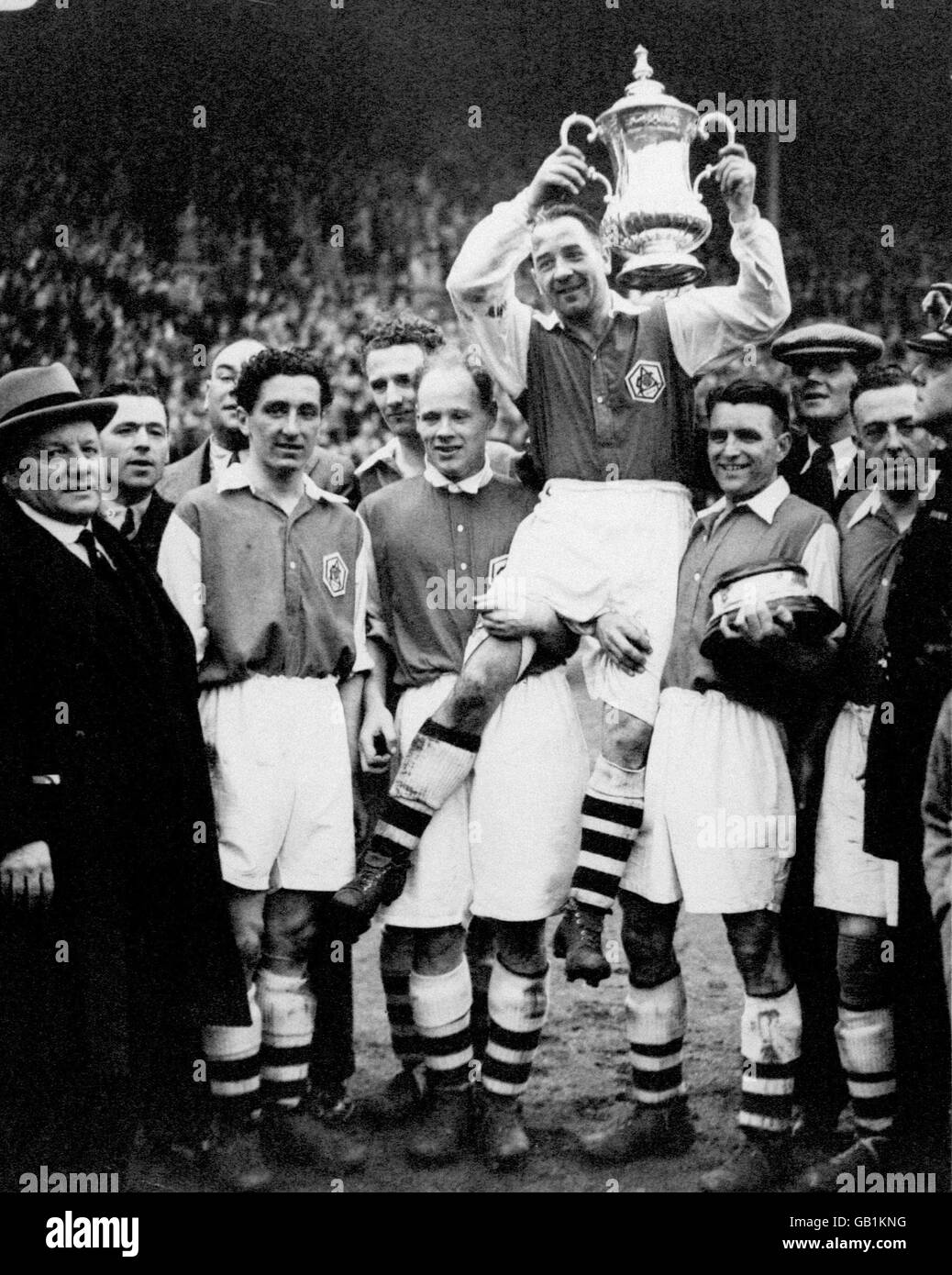 Arsenal captain Alex James shows off the FA Cup as he is held up by his ...