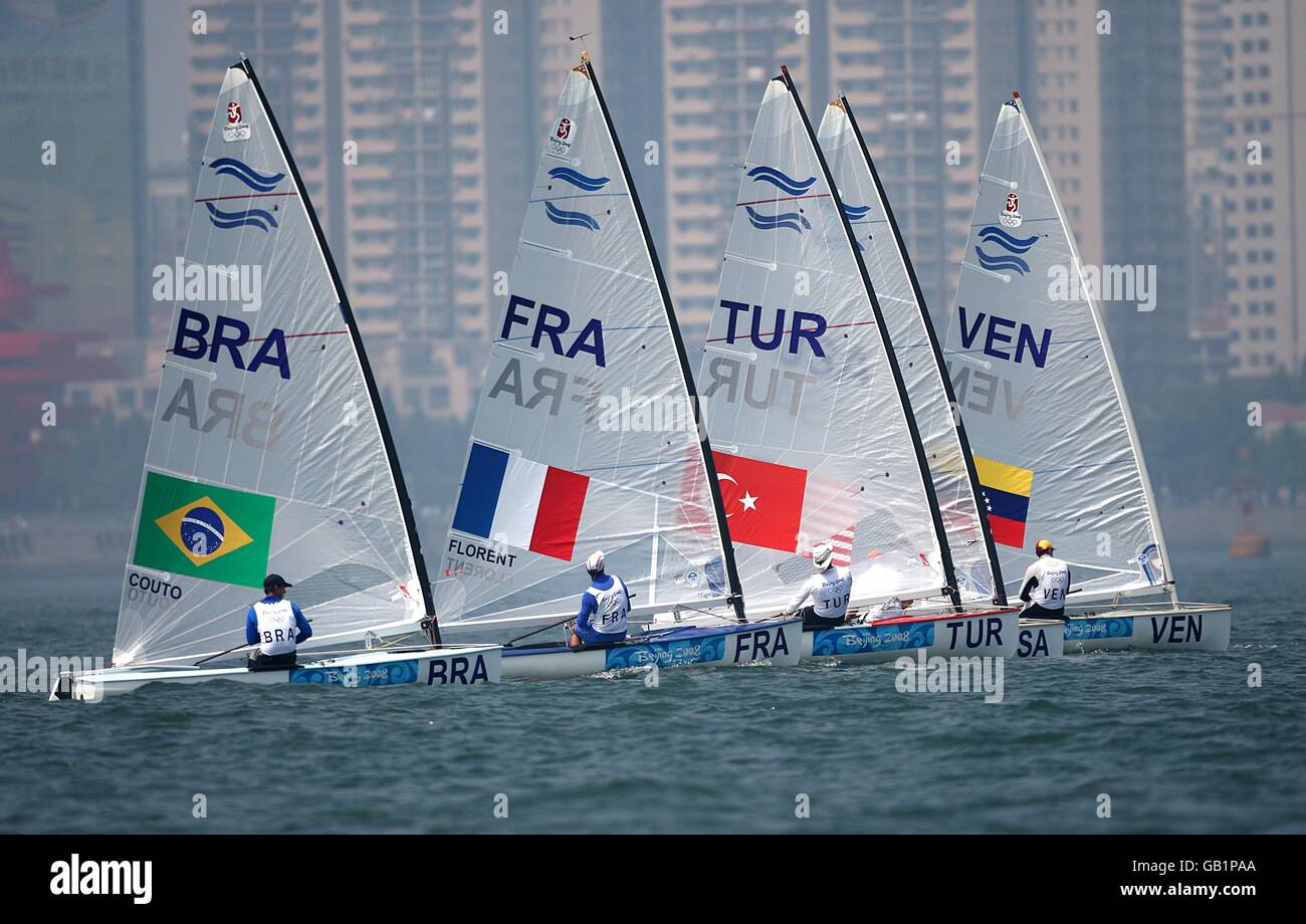 The Finn class field bunches up on the windward leg during the first ...