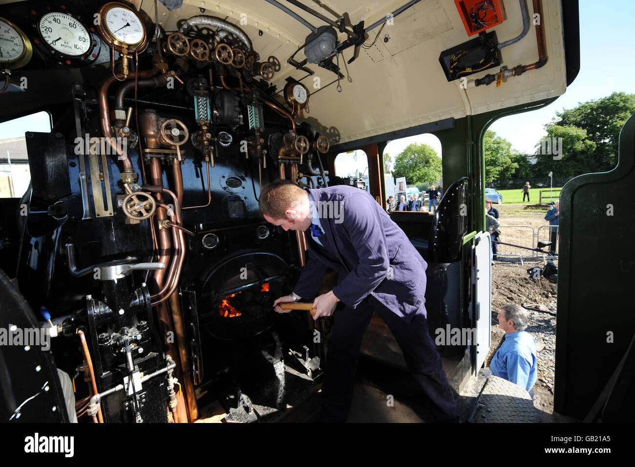 Graeme Bunker puts coal in the firebox onboard the Peppercorn Class A1 ...