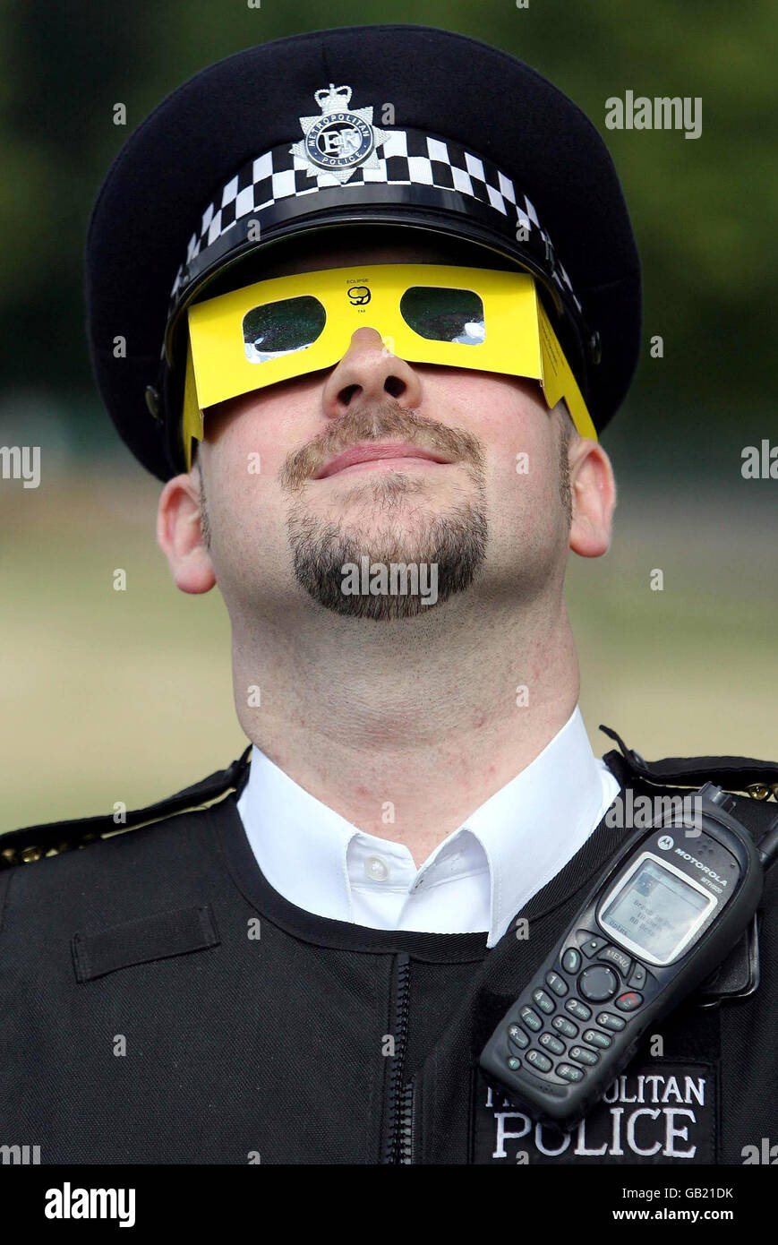 A Policeman looks at a partial solar eclipse of the sun in Hyde Park ...