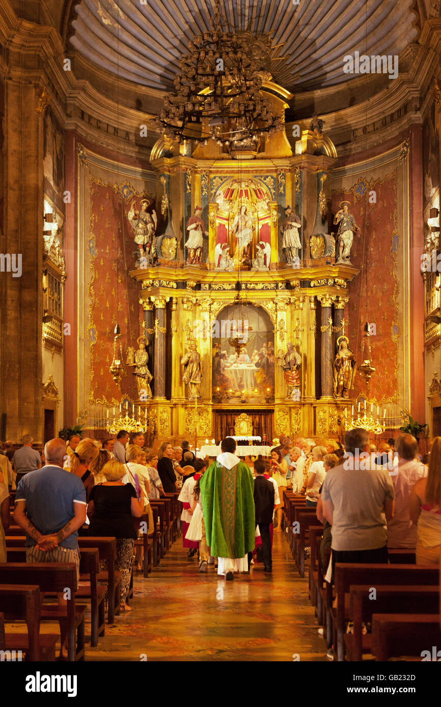 A catholic priest and congregation during a catholic mass; the interior ...