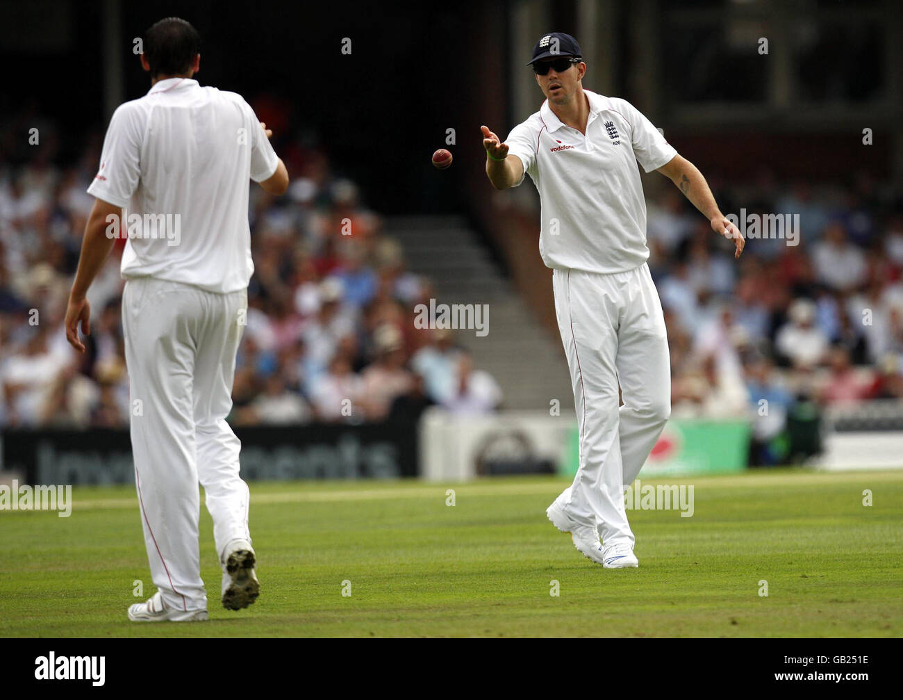 England captain Kevin Pietersen (right) throws the ball to Steve ...
