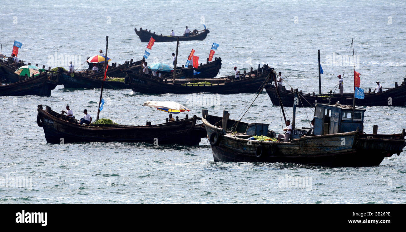 Local boats collect seaweed from the Olympic sailing course off Qingdao ...