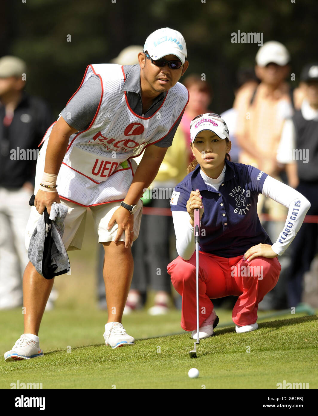 Japan's Momoko Ueda lines up a putt with the help of her caddy on the ...