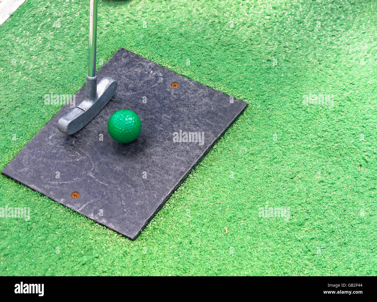 Mini golf ball on green carpet course Stock Photo - Alamy