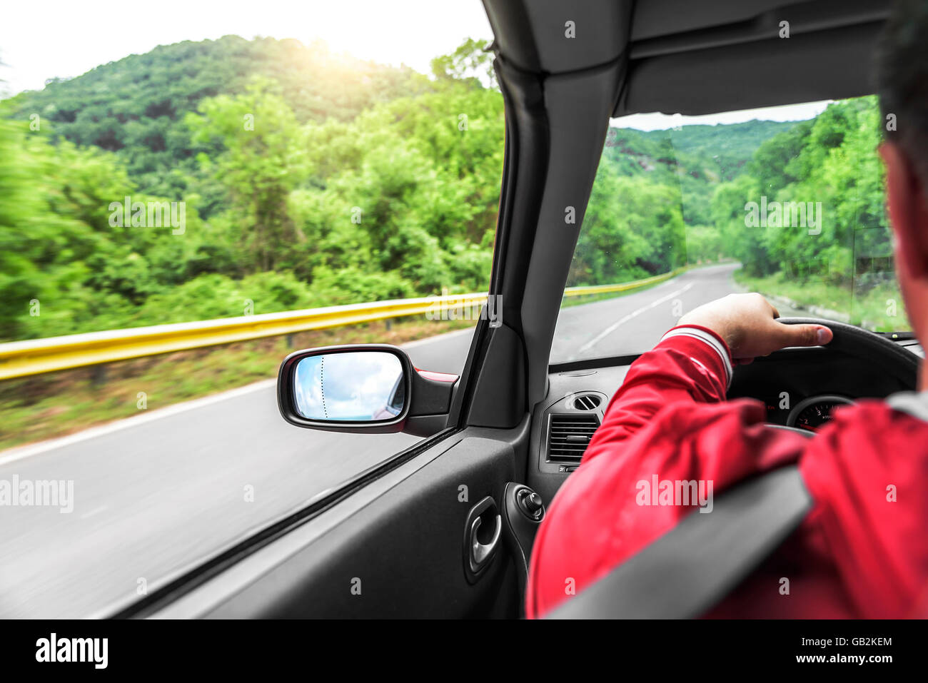 Male driver drives a convertible car on the country road. The view from ...