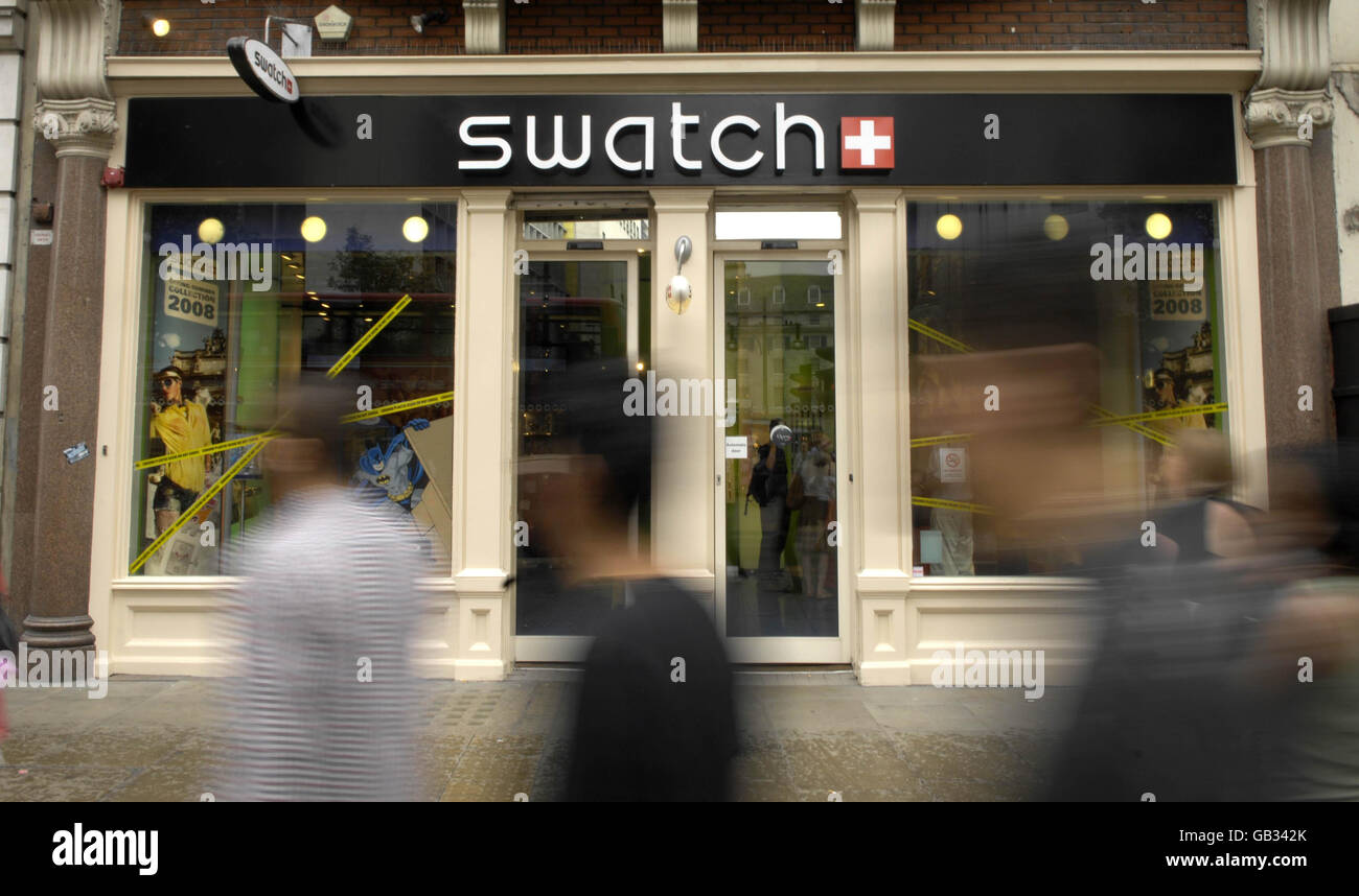General view of shoppers walking past a Swatch store on Oxford Street ...