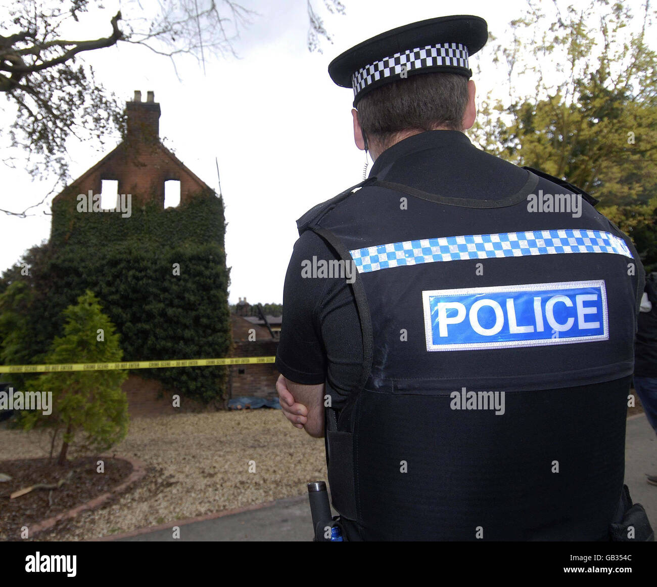 A Police officer on duty outside the burnt out family mansion, Osbaston ...