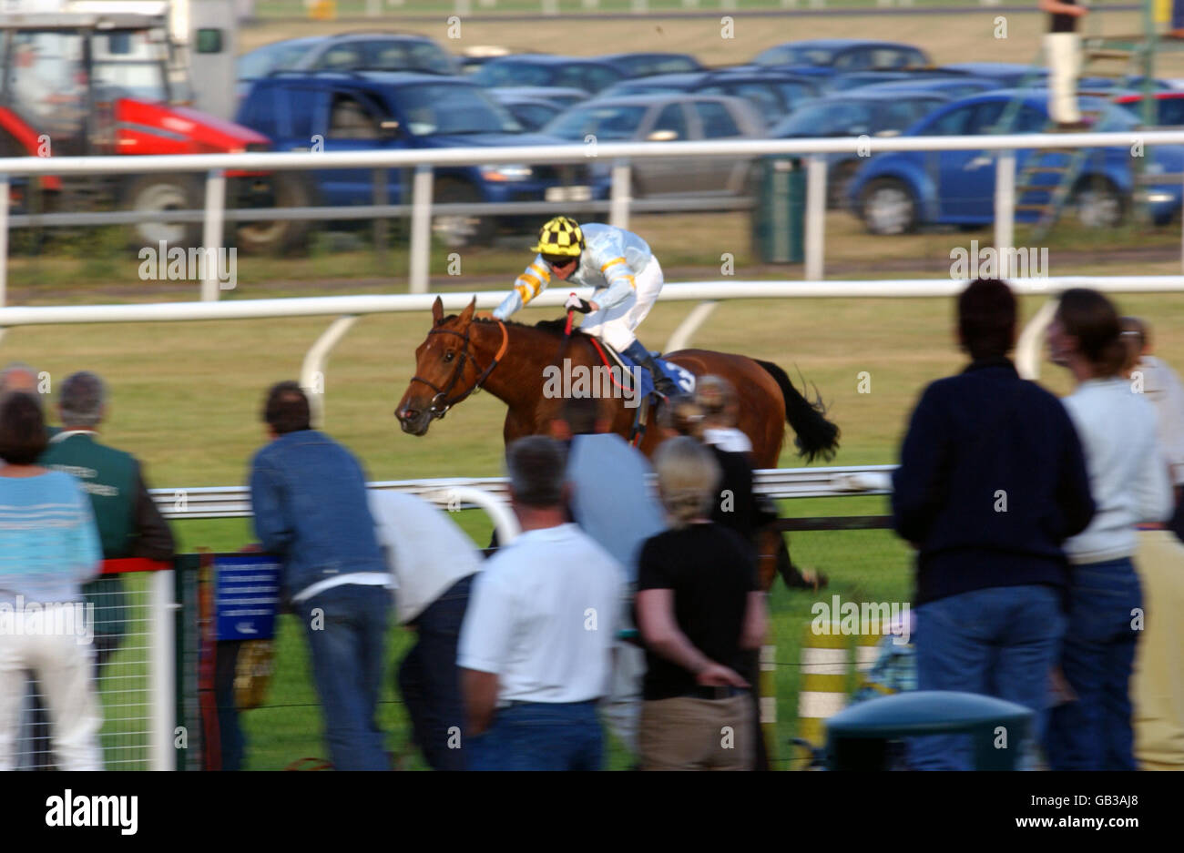 Horse Racing - Kempton Park Racecourse. A horses races past Stock Photo ...