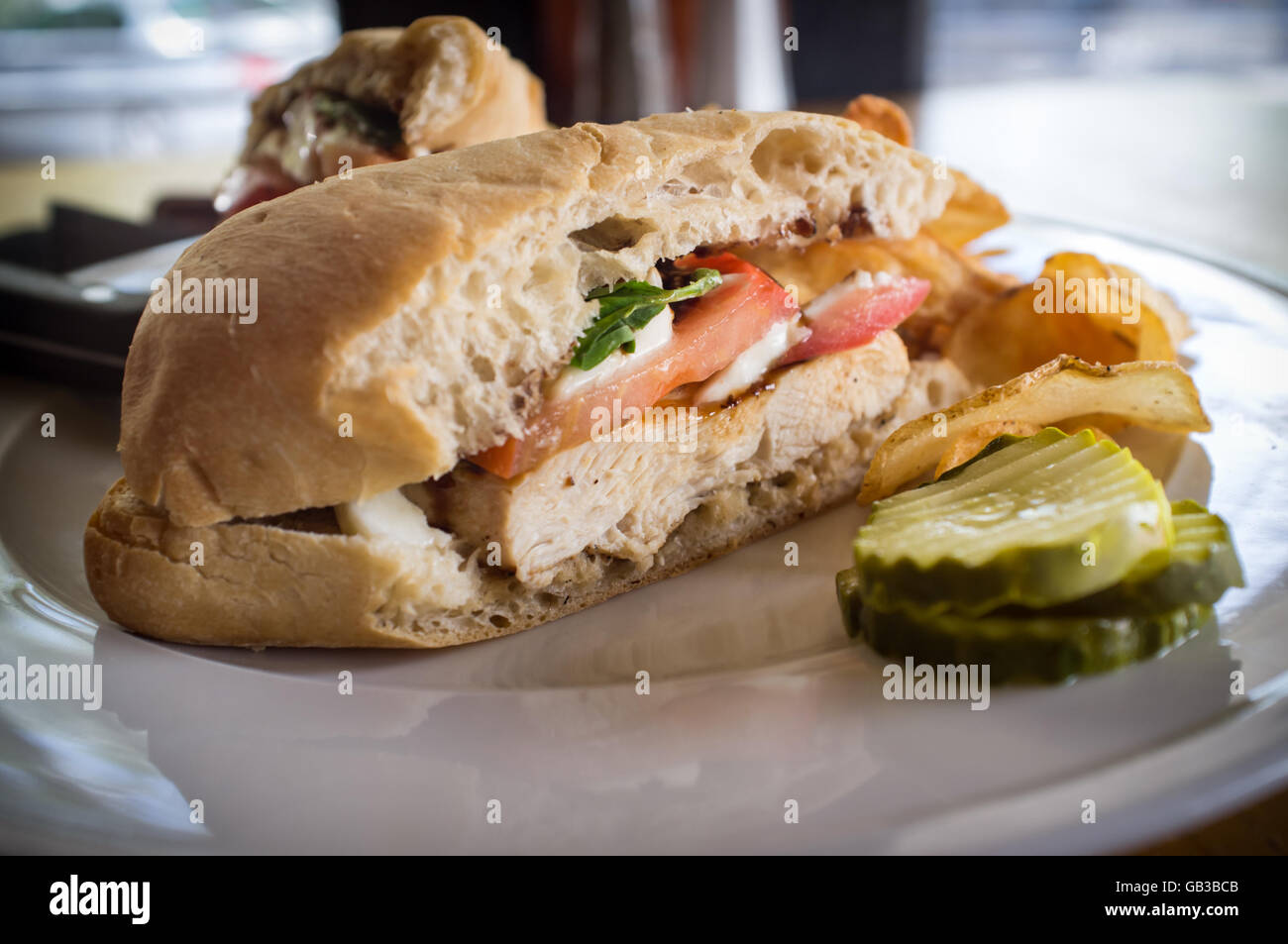 Grilled chicken panini with crispy home made chips Stock Photo - Alamy