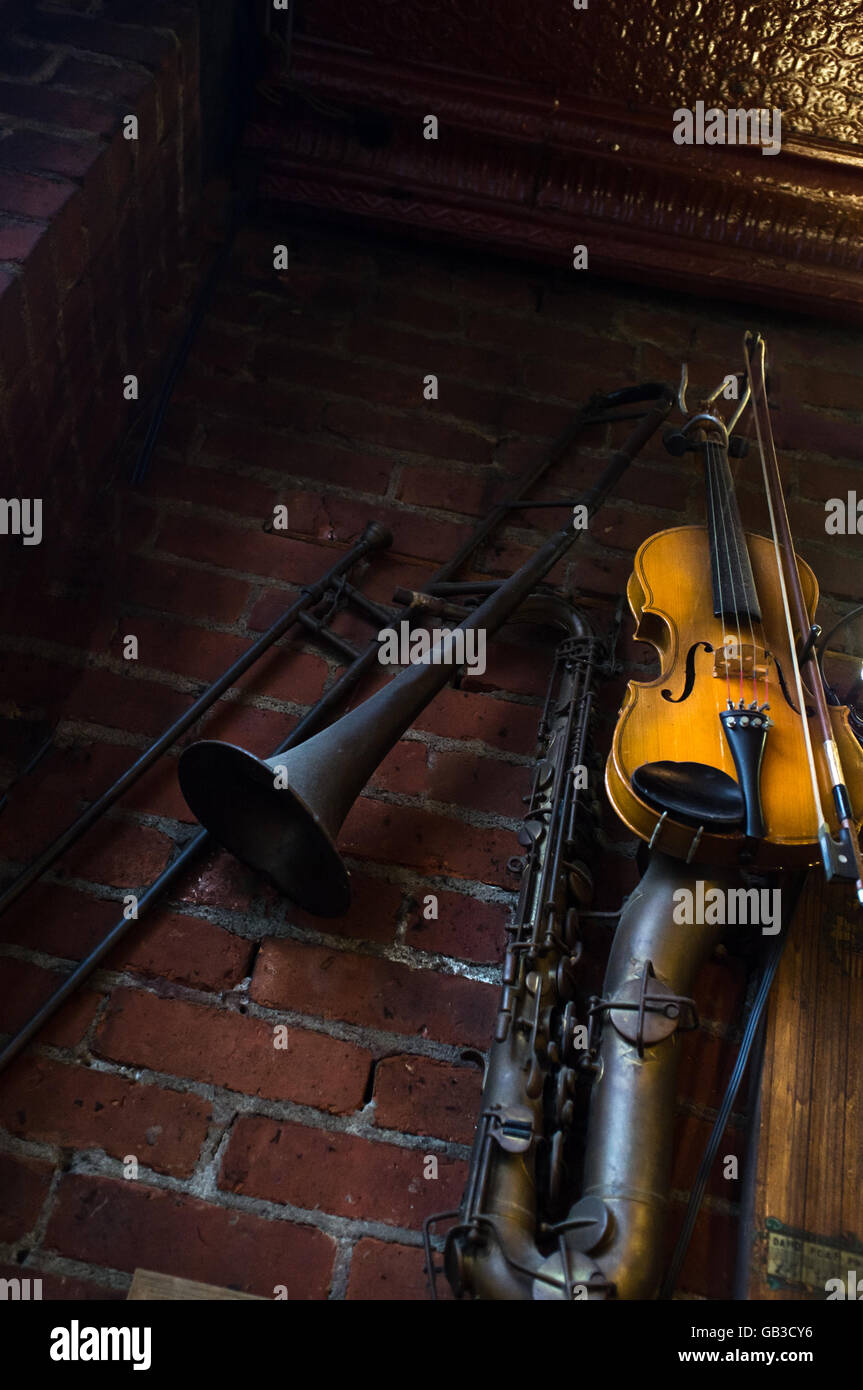 Jazz club instruments hang on brick wall at night Stock Photo - Alamy