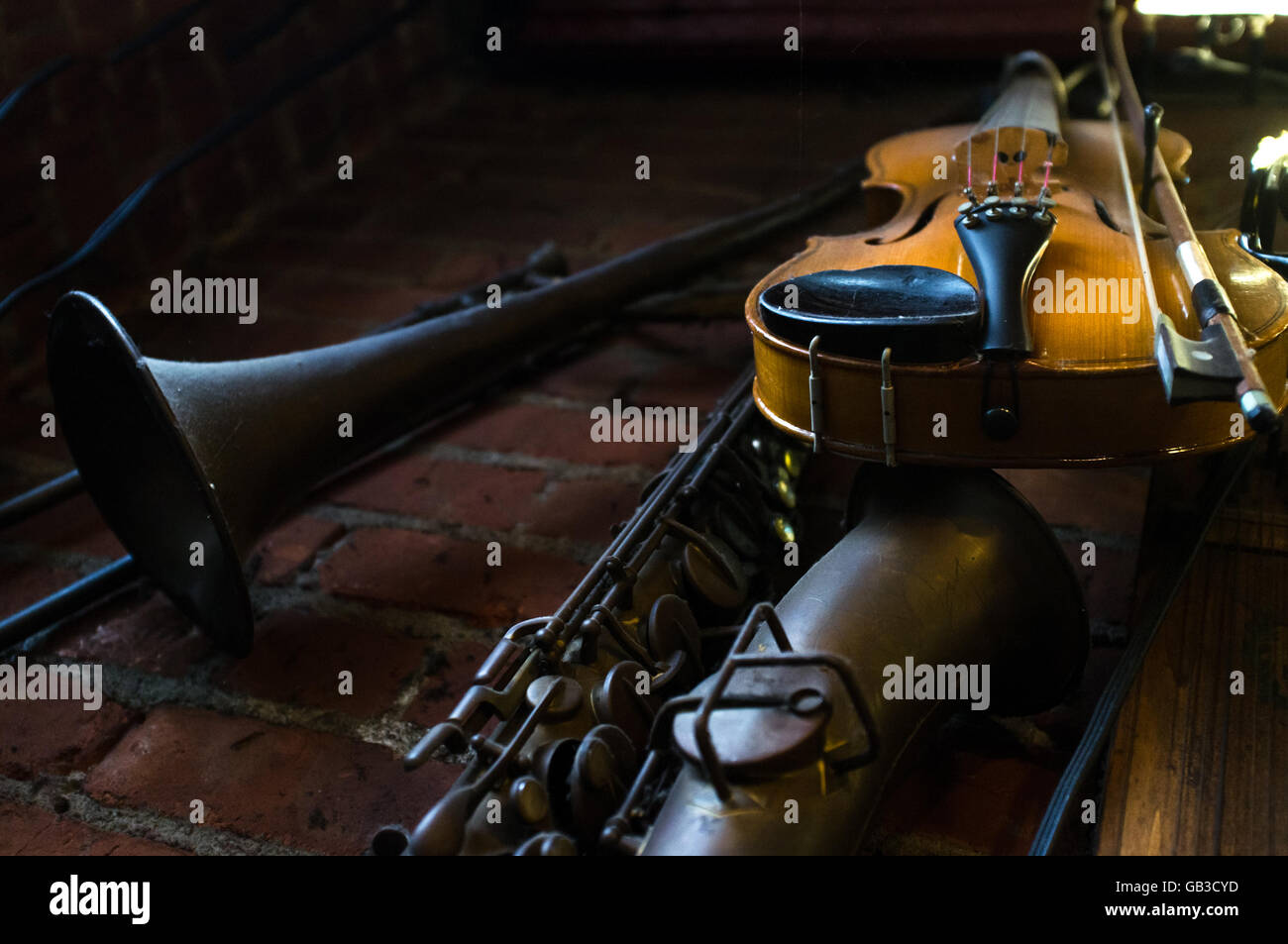 Jazz club instruments hang on brick wall at night Stock Photo - Alamy