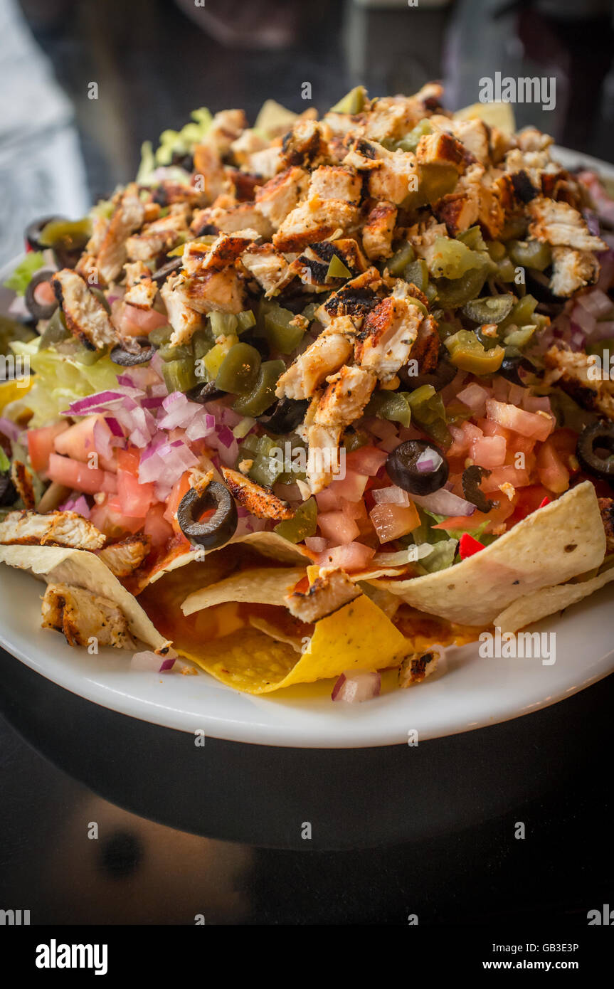 Colorful Mexican nachos with chicken black olives melted cheese ...