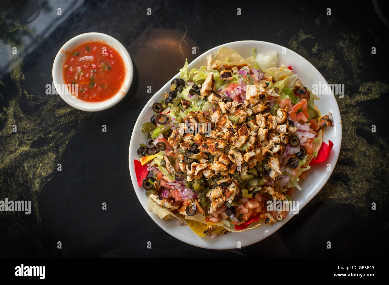 Colorful Mexican nachos with chicken black olives melted cheese ...