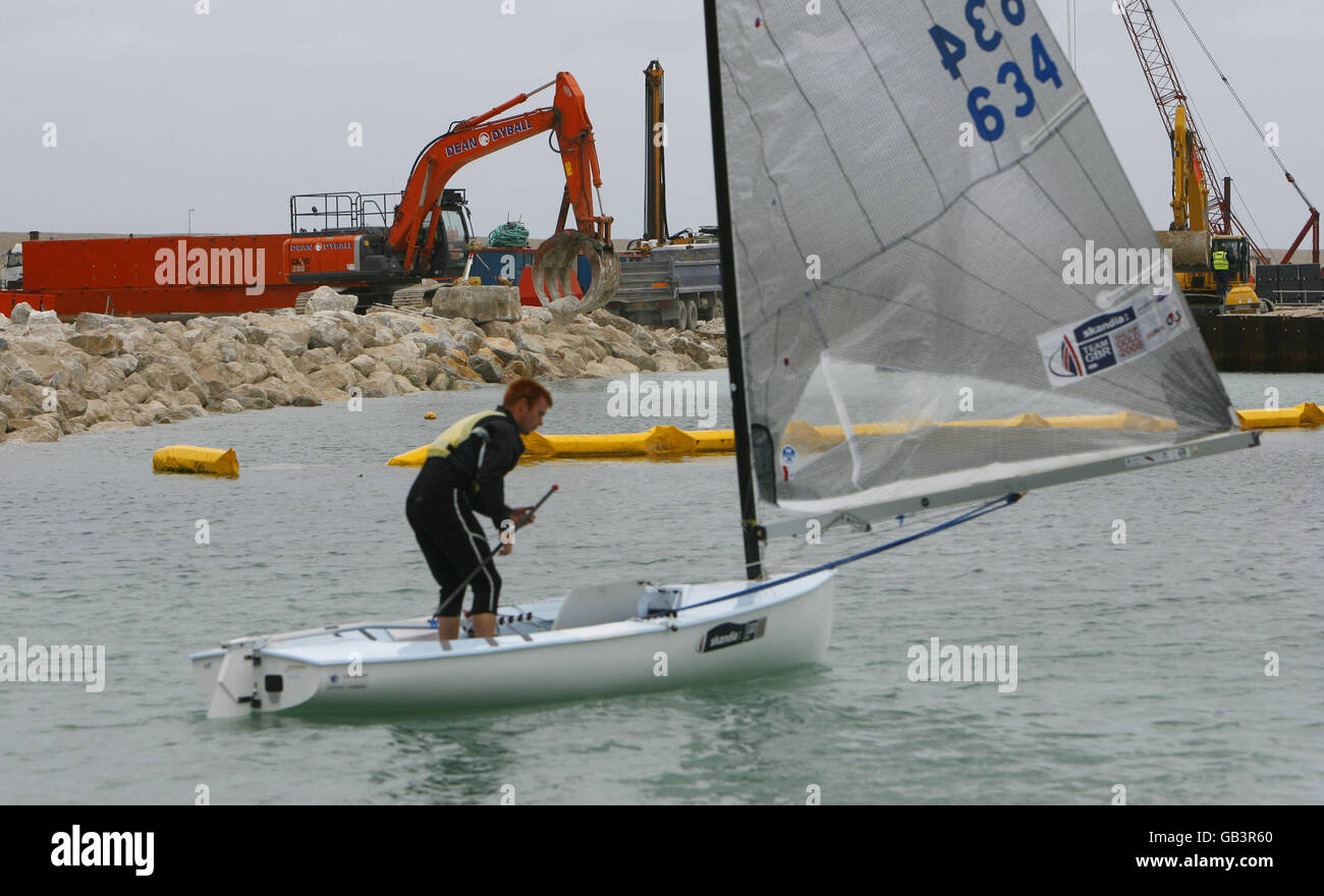 A Finn class sailor passes the ongoing construction work at the ...