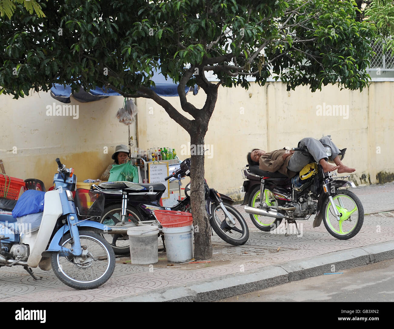A man sleeps on his motorcycle in Ho Chi Minh City, Vietnam Stock Photo ...