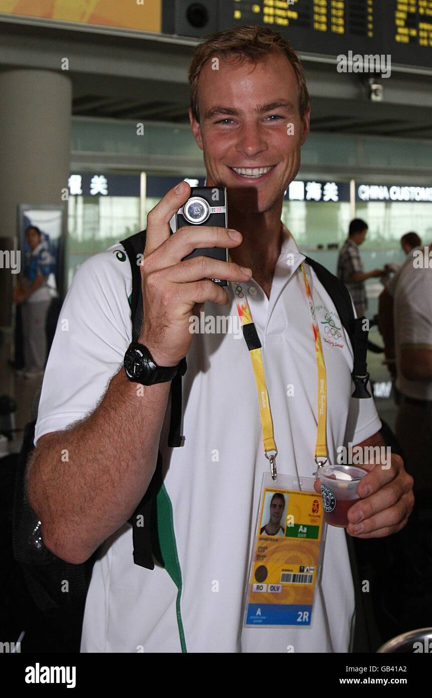 Irish rower Jonno Devlin takes pictures of the photographers after arriving at Beijing Airport ...