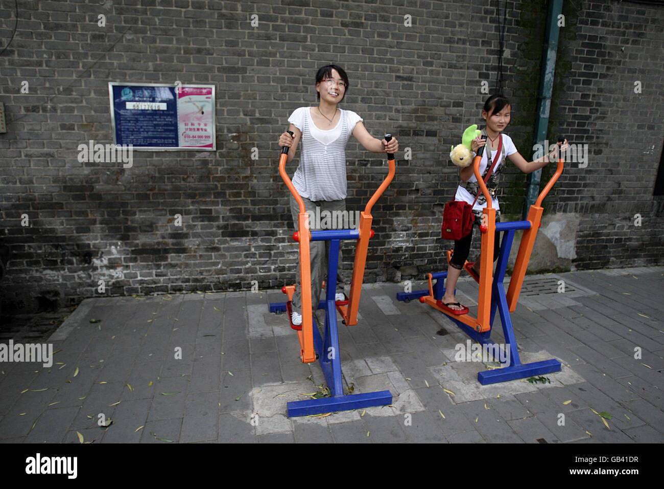 Two women using keep fit machines on the streets of Old Beijing in ...