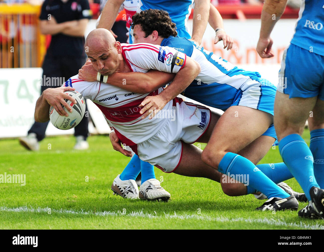 Hull KR's Mick Vella (in white) goes over to score a try under pressure ...