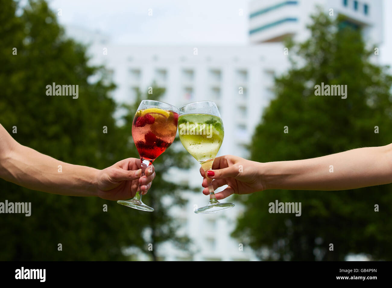 Hand holding glasses cocktail clinking together at outdoor Stock Photo ...