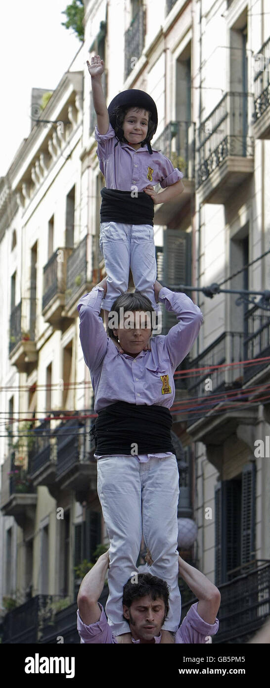 A young child forms the top level of a human "Castell" during the ...