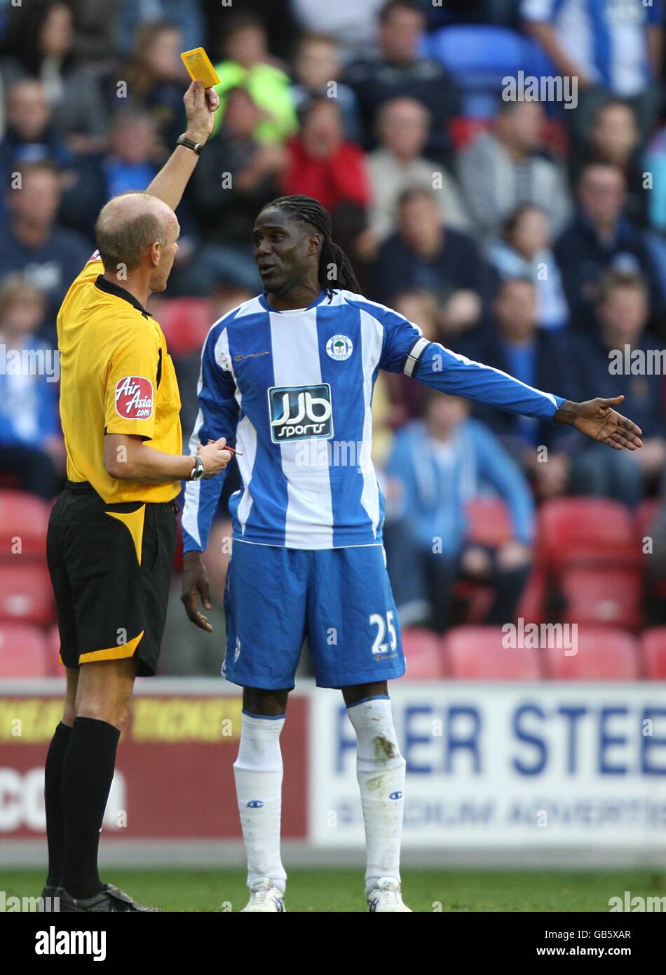Referee Steve Bennett shows Wigan Athletic's Mario Melchiot a yellow ...