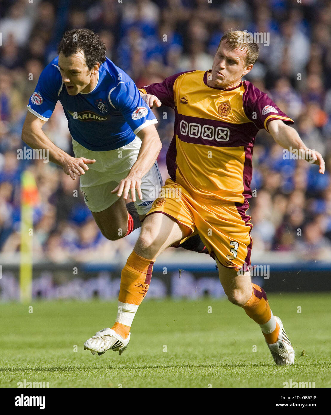 Rangers' Christian Dailly is tackled by Motherwell's Stevie Hammell ...