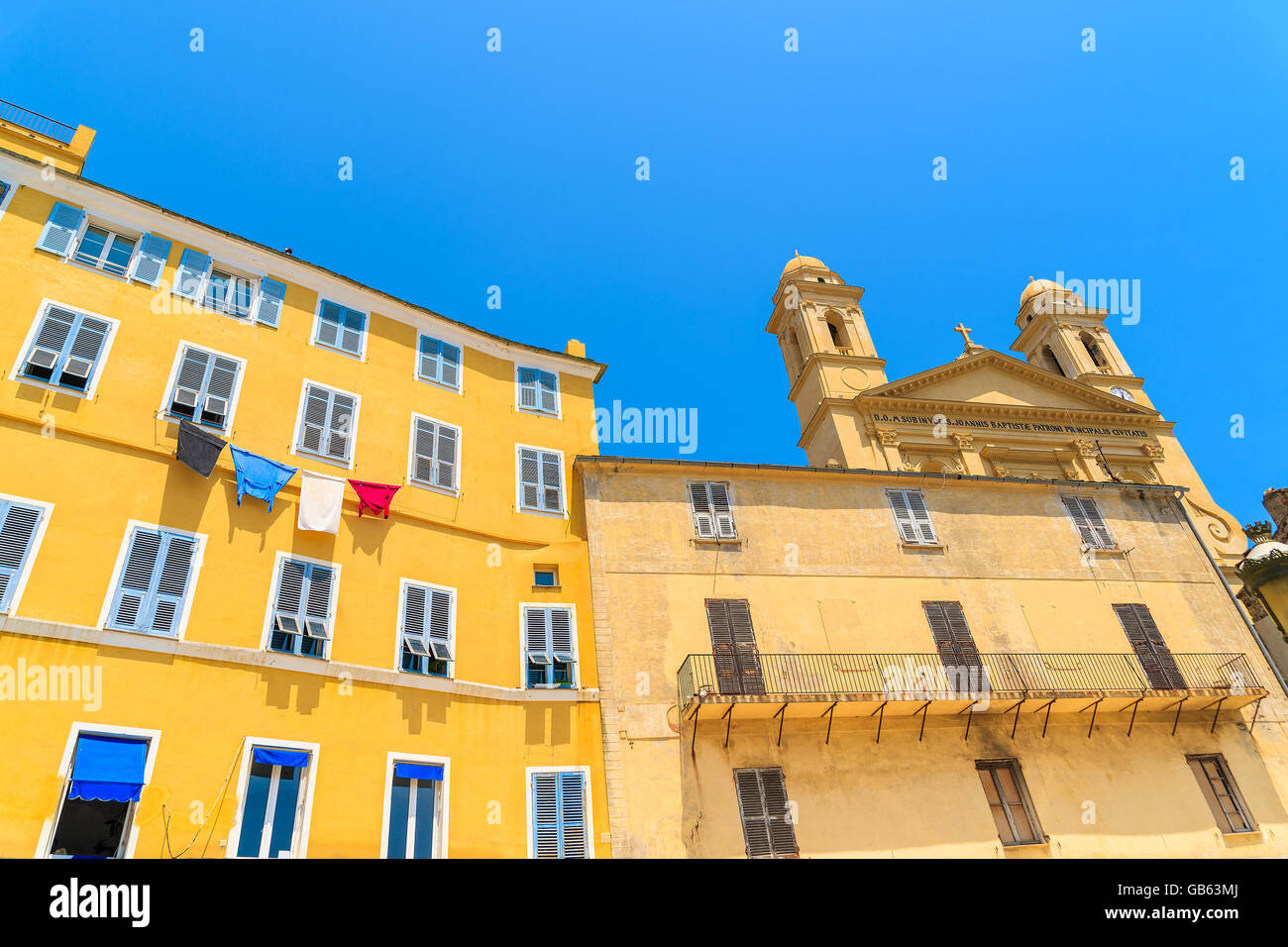 Yellow Corsican house facade and cathedral building in Bastia port ...