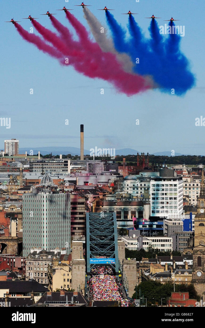 Competitors cross the Tyne Bridge as the Red Arrows fly over during the ...