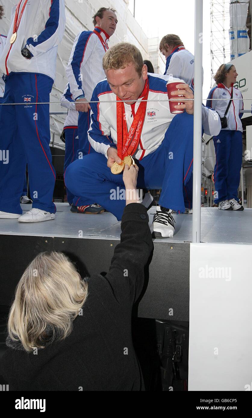 Triple gold medalist Chris Hoy shows off her medal during the Team GB ...