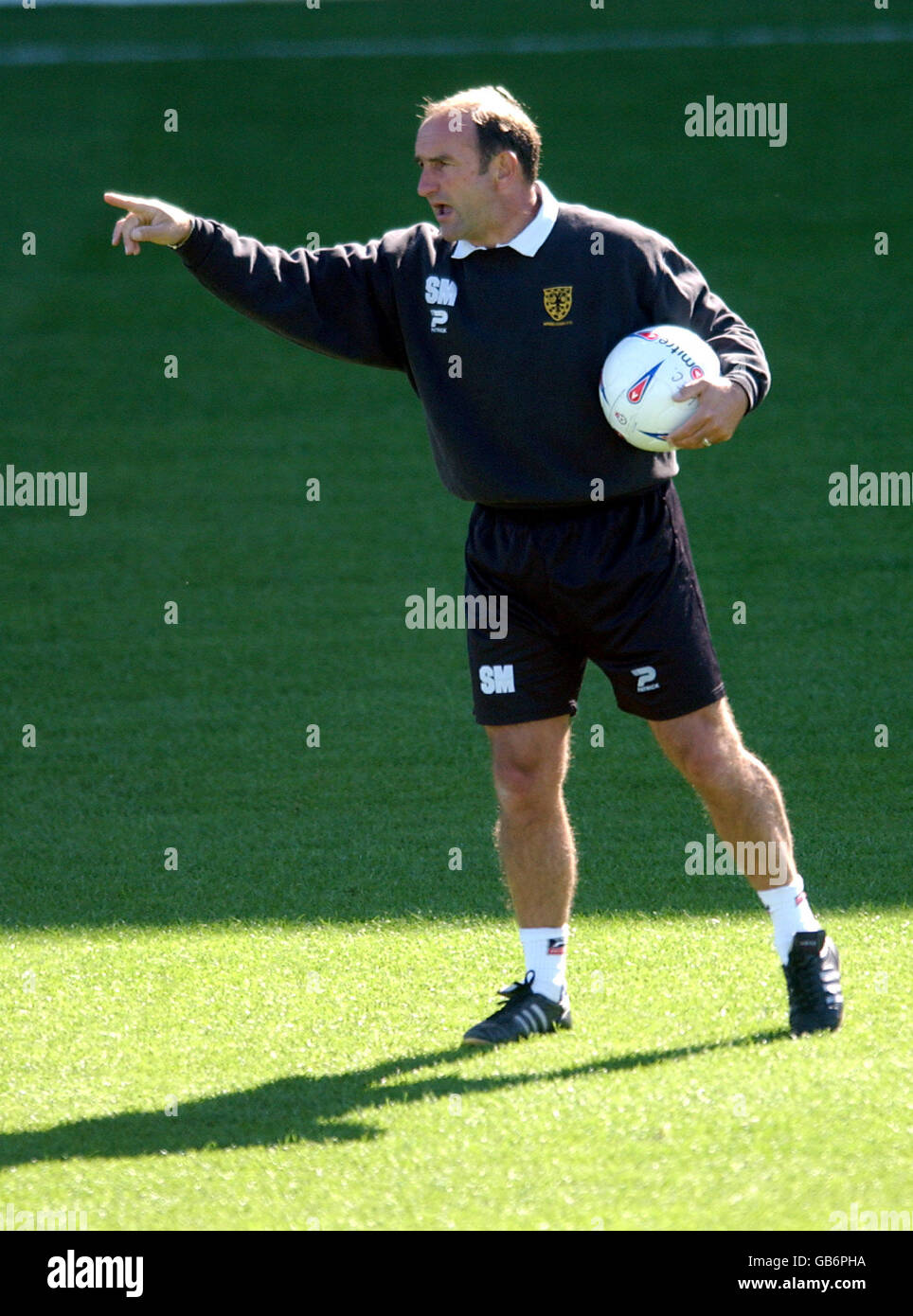 Wimbledon's manager Stuart Murdoch points out instructions to his ...